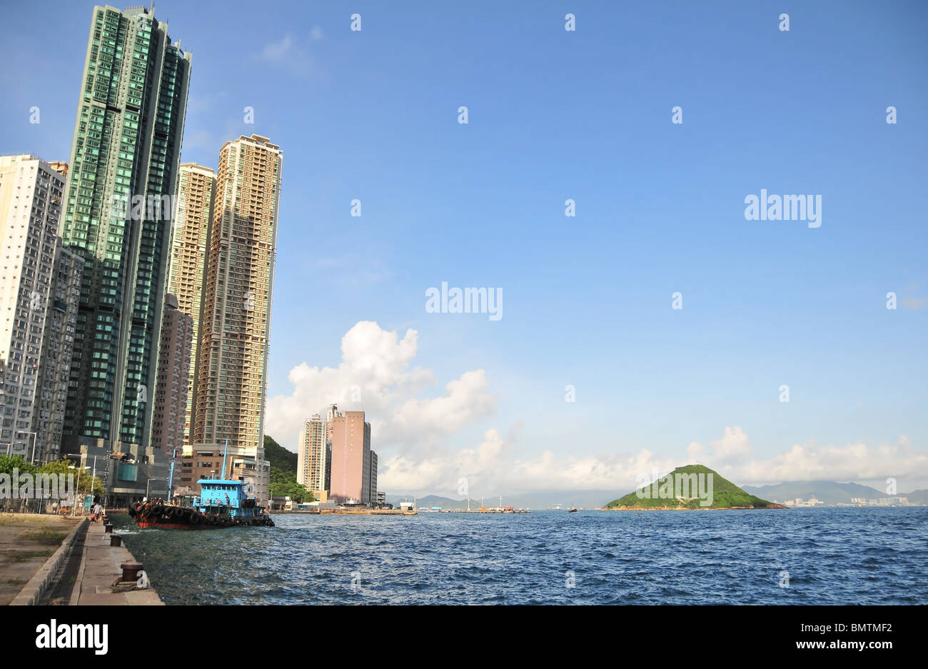 Blue sky view of dangerous cargo tugboat at stone wharf below ...
