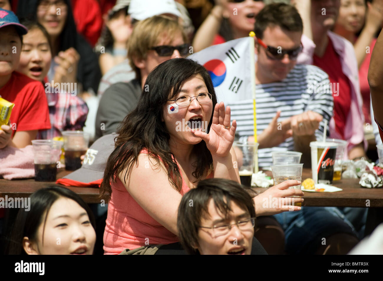 A South Korean football supporter shouting support to her team while ...