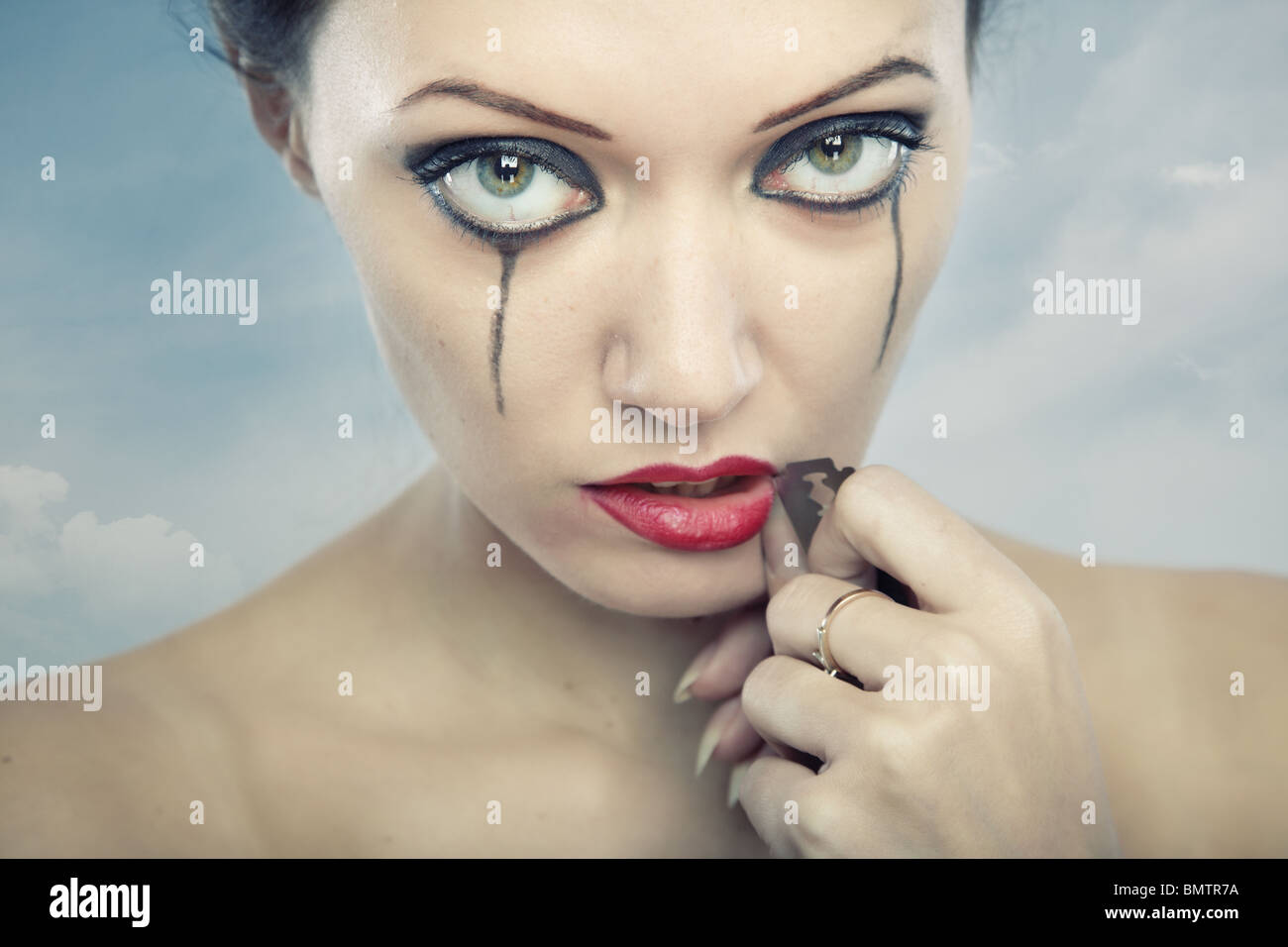Portrait of the Gothic lady holding razor and cutting lips. Special ...