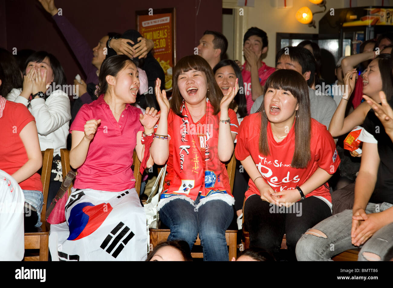 Excited young South Korean women football supporters watching their ...