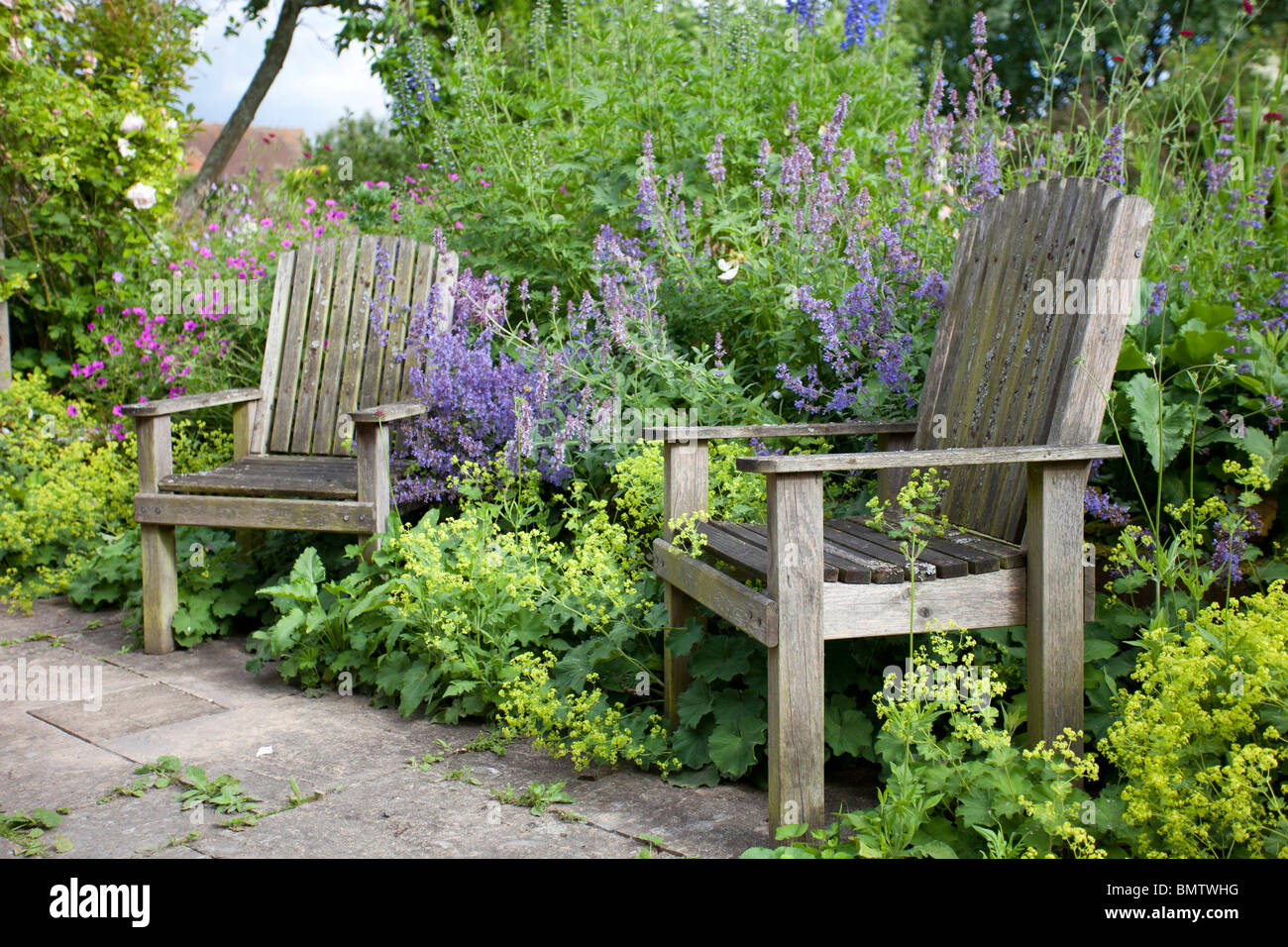 garden chairs with plants background Stock Photo - Alamy