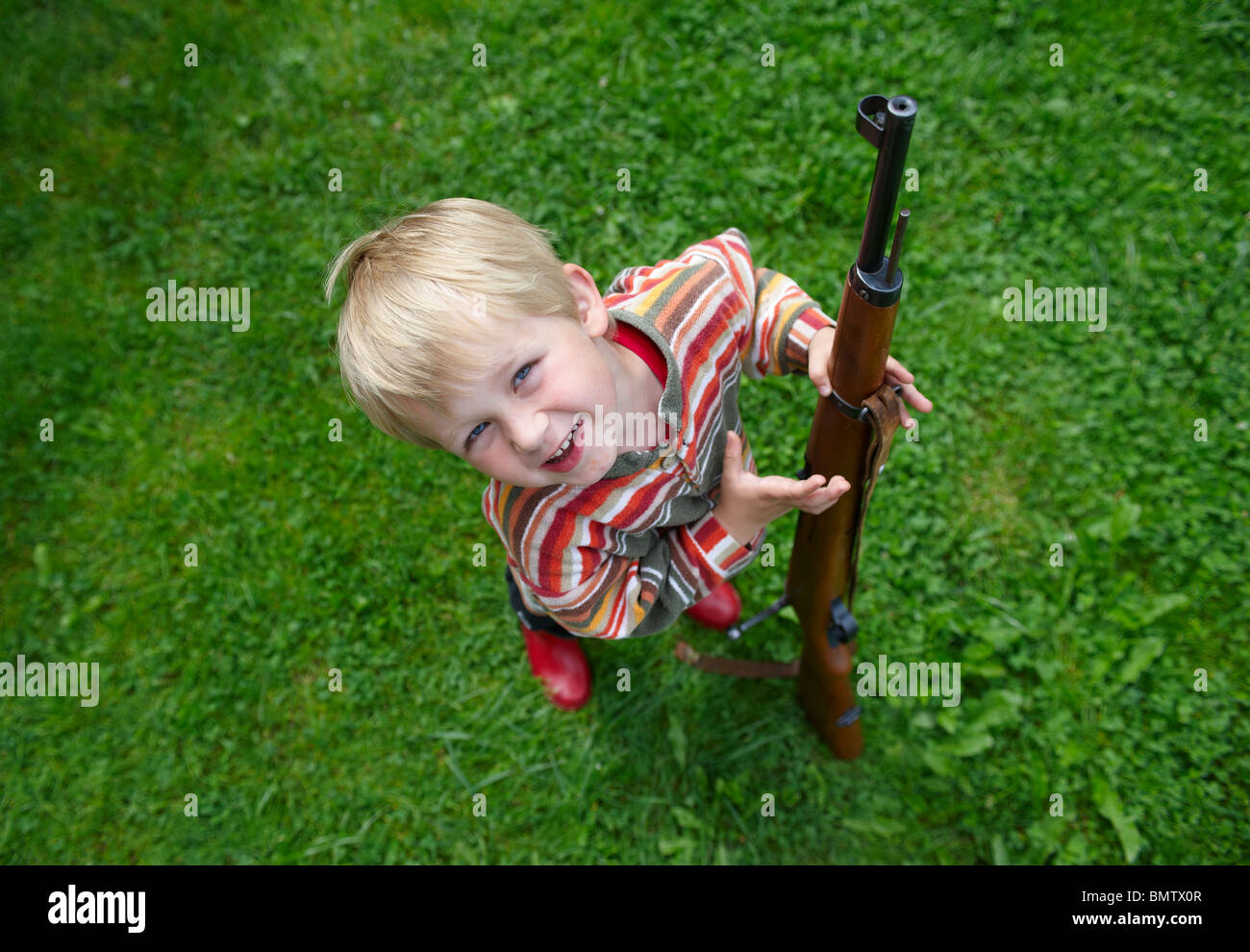 Child blond boy playing with air gun Stock Photo - Alamy