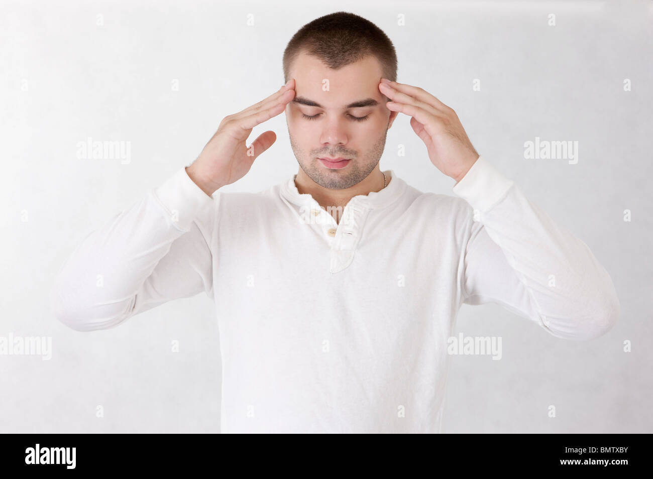 Young man putting hands on head and thinking with eyes closed Stock ...