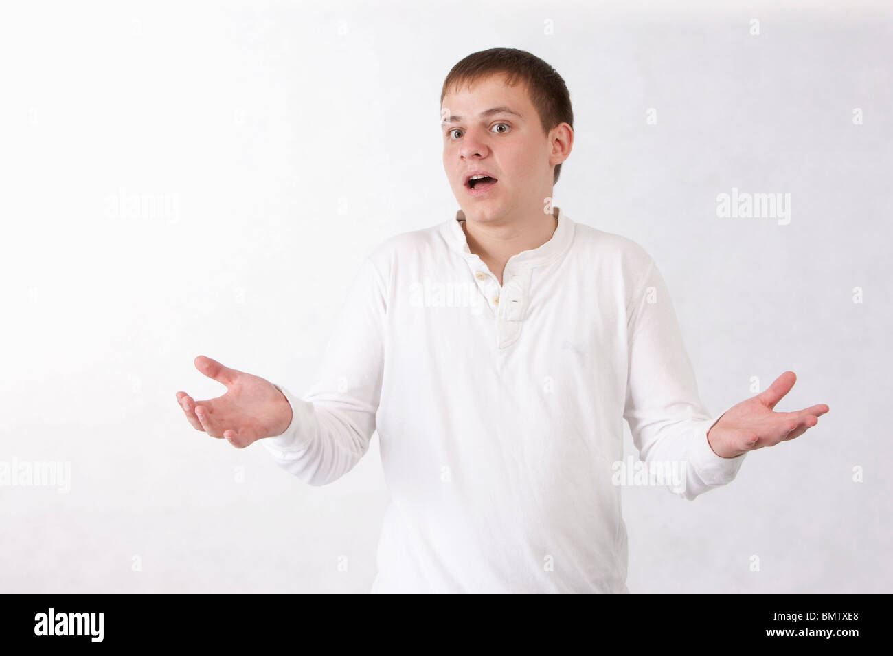 Young man shrugging Stock Photo - Alamy