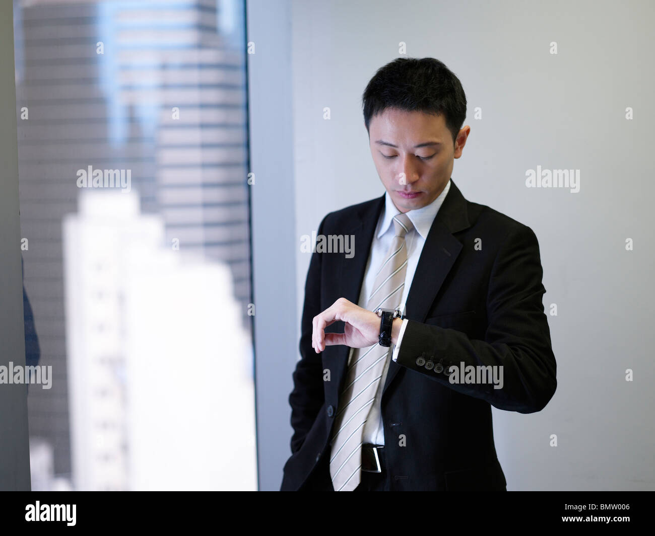 Businessman looking at watch Stock Photo - Alamy
