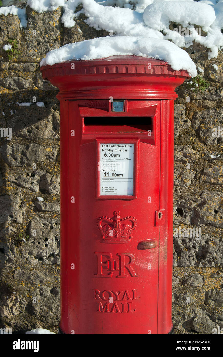 A red "Royal Mail" pillar box with snow on the top photographed in ...