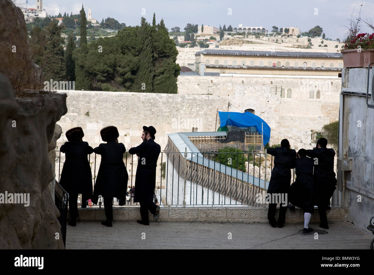 Orthodox Hasidic Jews in old Jerusalem looking over fence towards ...