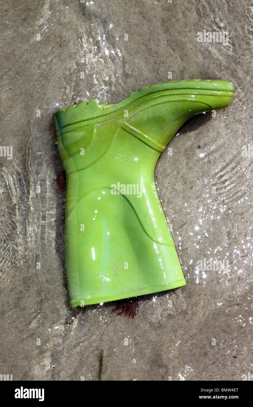 green boots trash on beach shore pollution human waste concept Stock ...