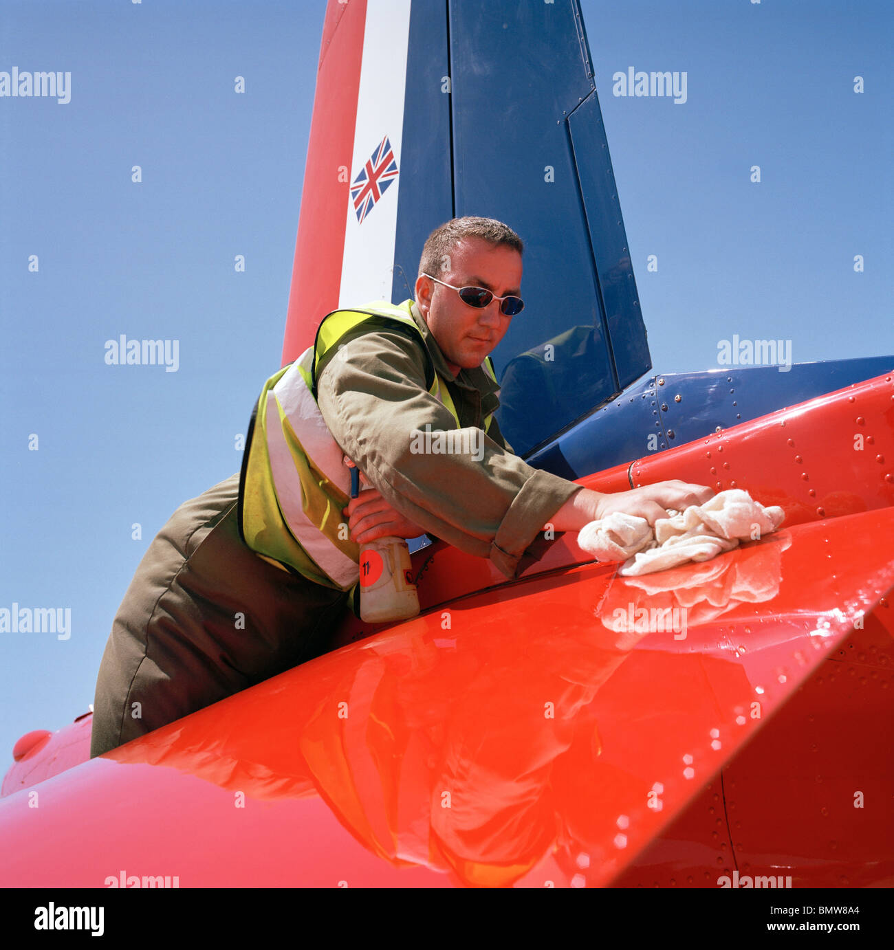 Engineer polishing Red Arrows aerobatic jet aircraft's flying surfaces ...
