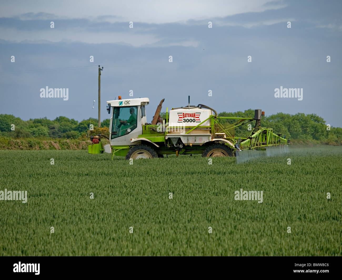 A watering van spraying water across a green field Stock Photo - Alamy