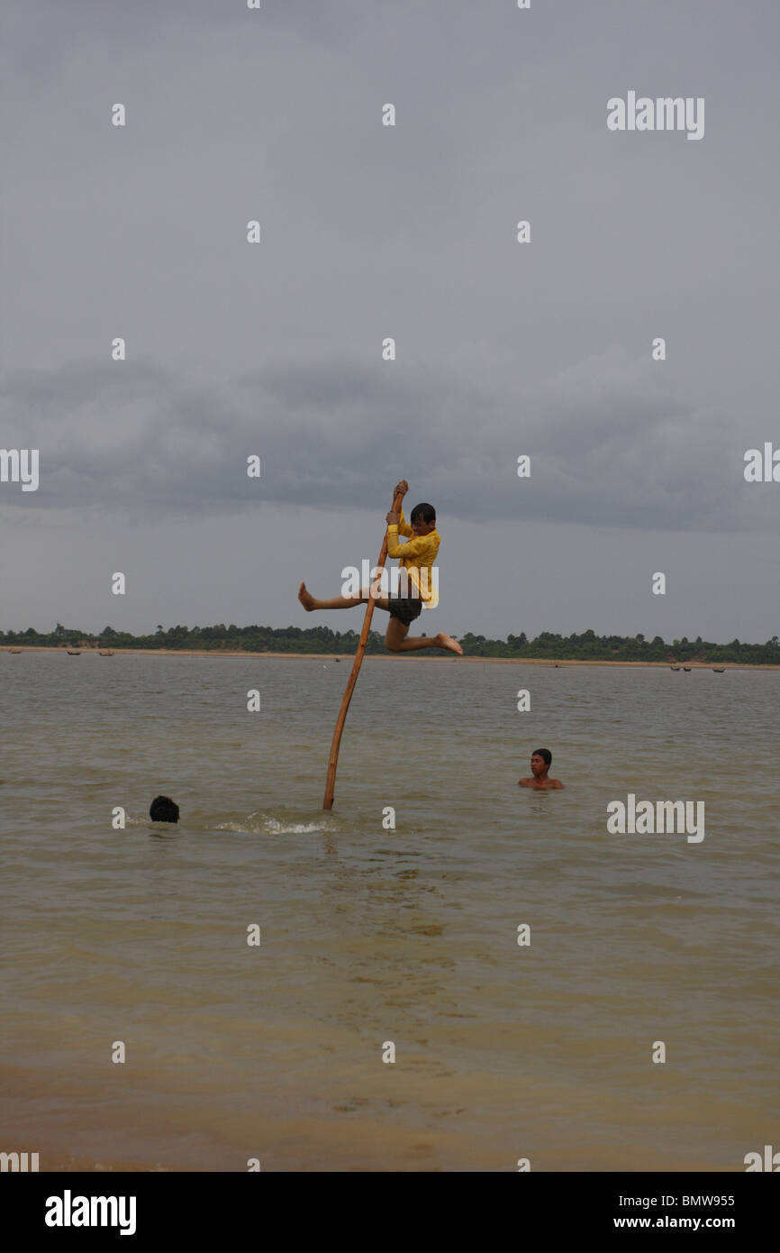 A boy has climbed a b pole in the Western Baray, a gigantic water ...