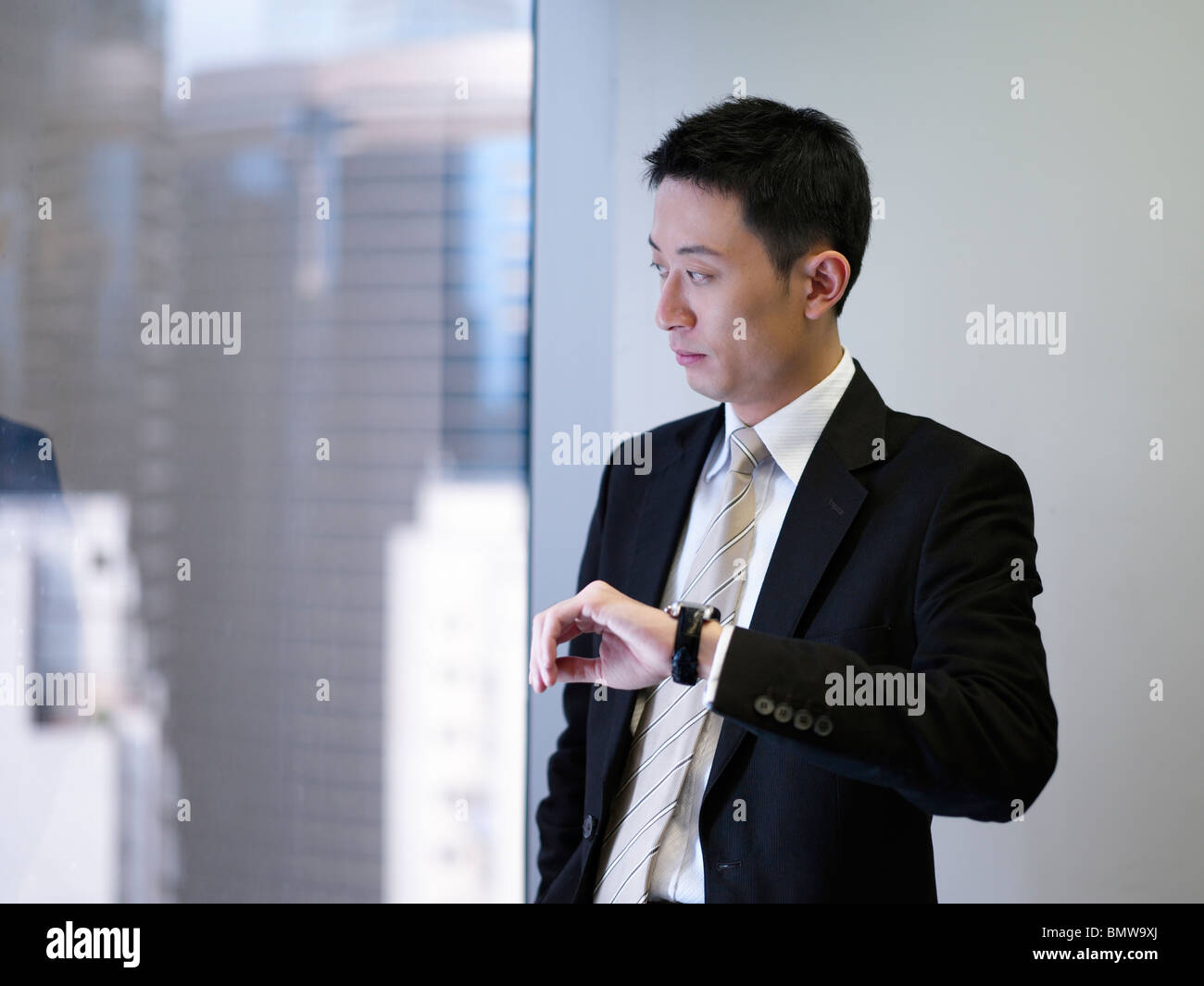 Businessman looking at watch Stock Photo - Alamy