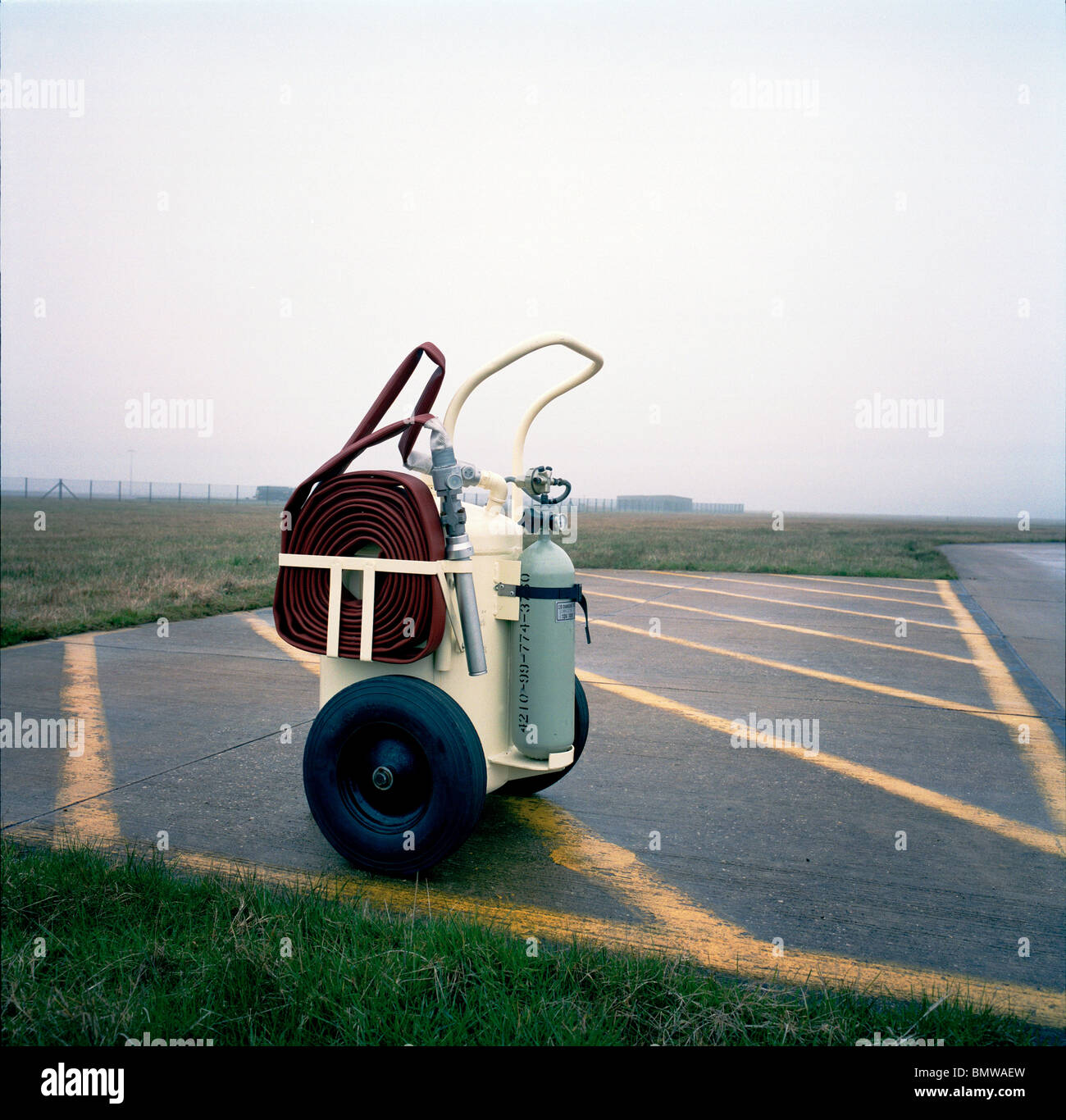Ageing MoD airfield fire extinguisher alone in the mist at RAF Scampton ...