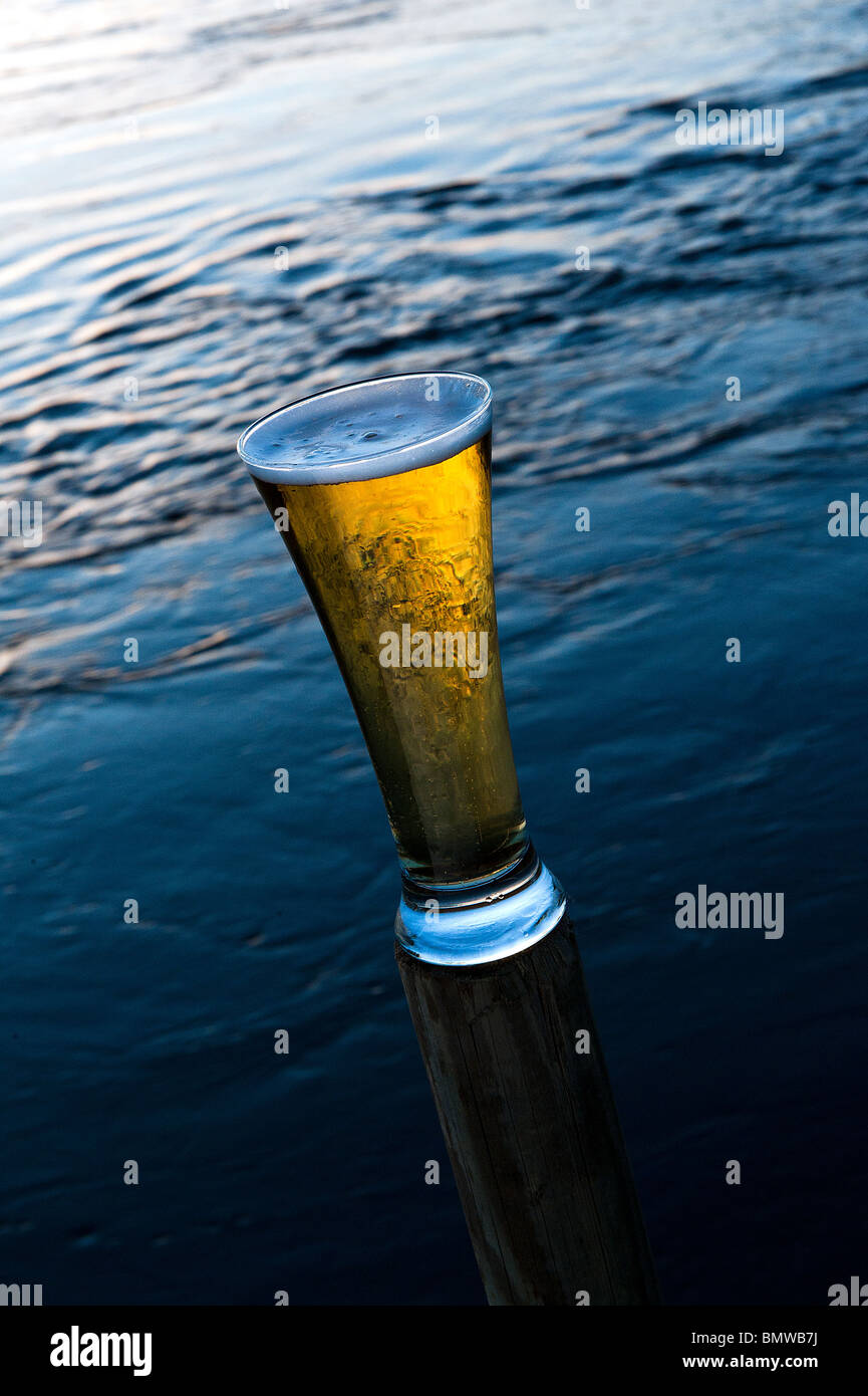 a glass of cold beer placed at the waters edge Stock Photo - Alamy