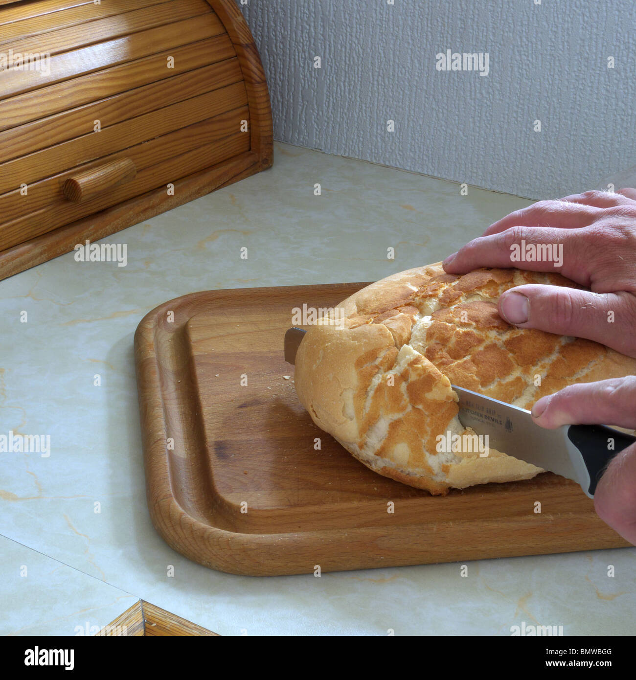 Slicing a White Crusty Loaf on a Breadboard MODEL RELEASED Stock Photo ...