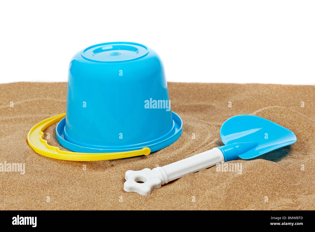 Bucket full and shovel on the sand with copy space on a white ...