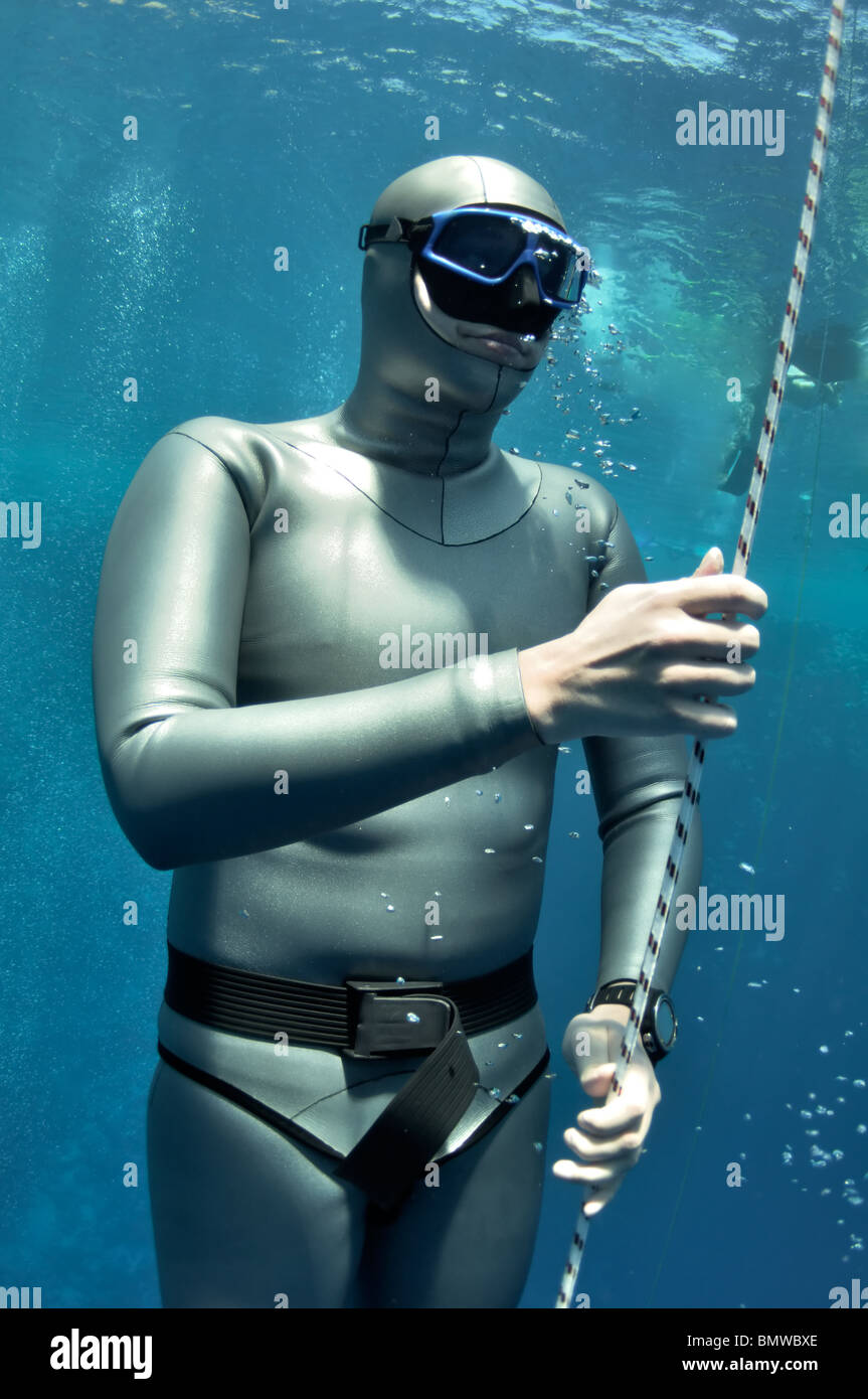 Smiling freediver raises from the depth by rope safety line Stock Photo ...