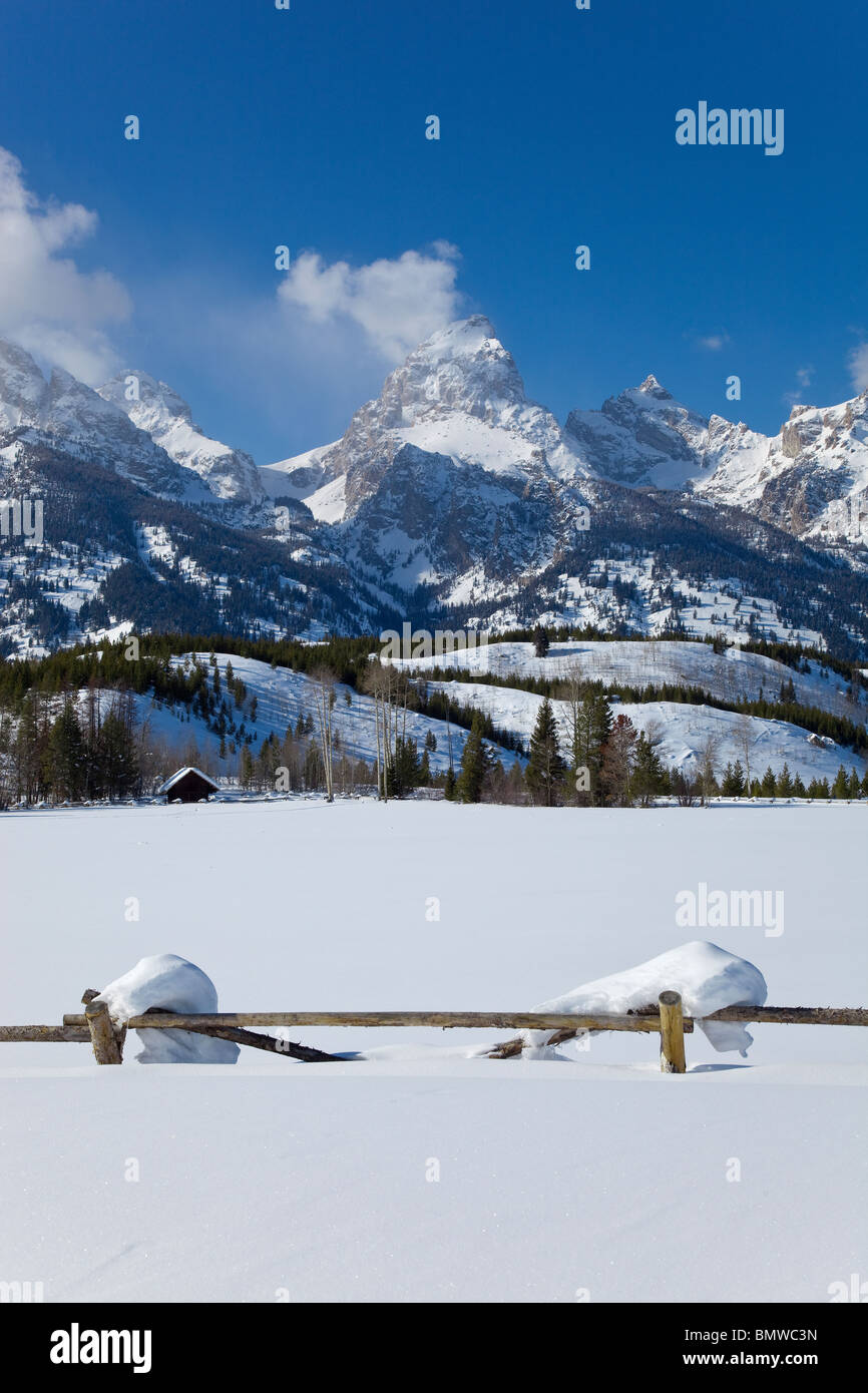 Grand Teton National Park, WY Snow capped fence line with the peaks of ...