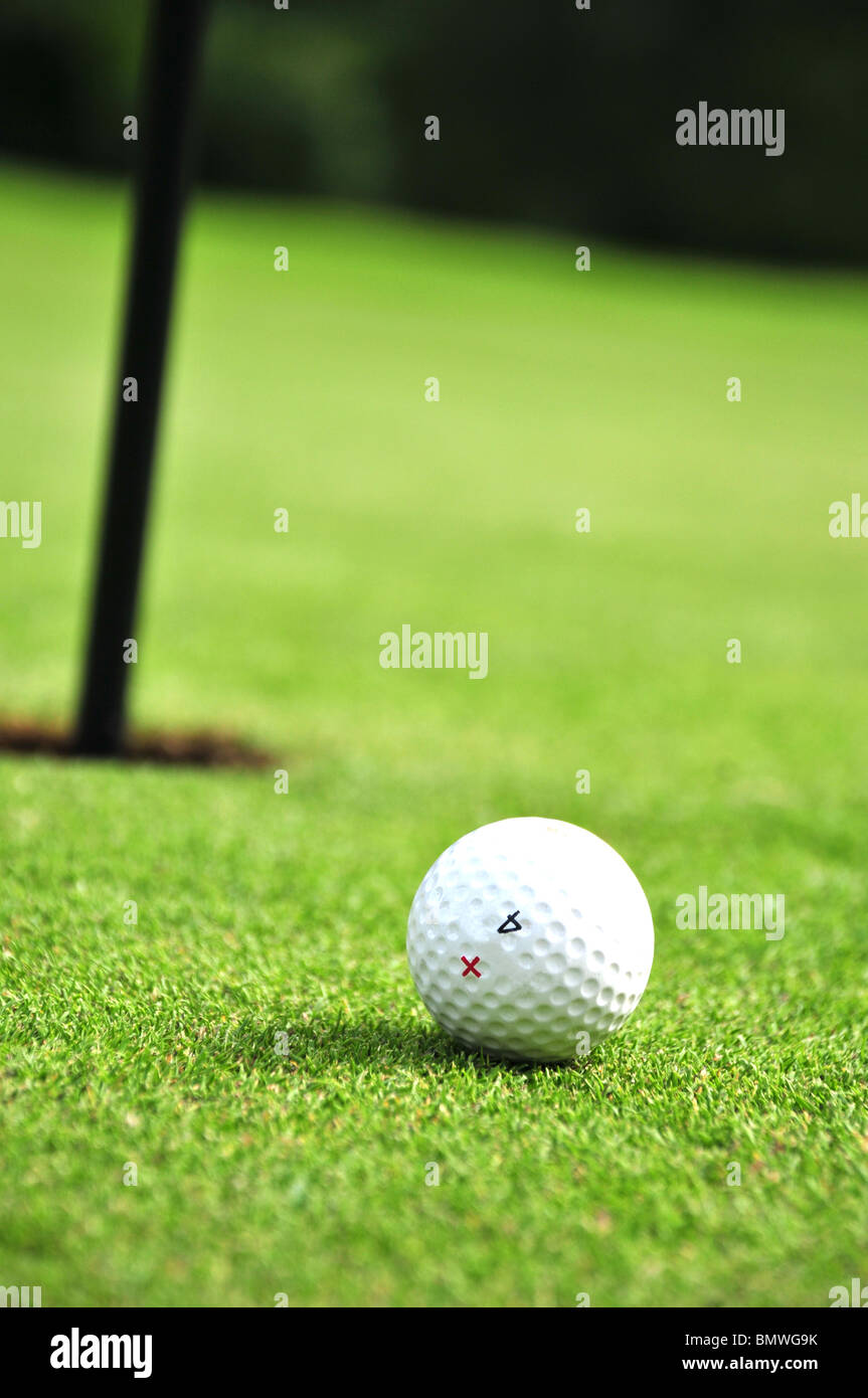 Seen from groUnd level a golf ball in close proximity to a hole with ...
