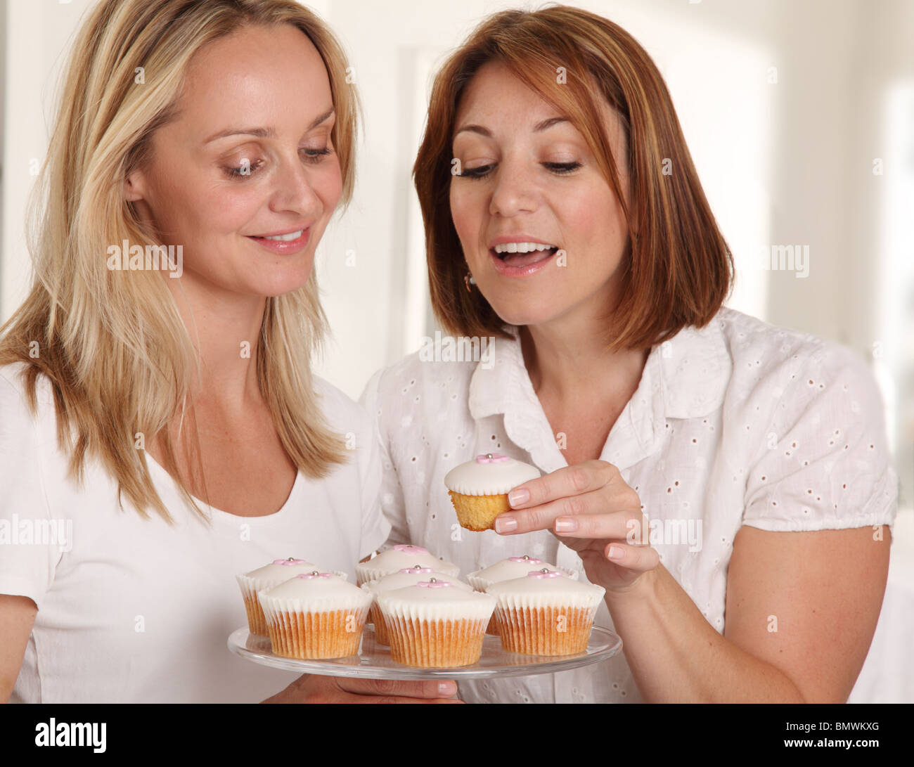 TWO WOMEN EATING CUPCAKES Stock Photo - Alamy