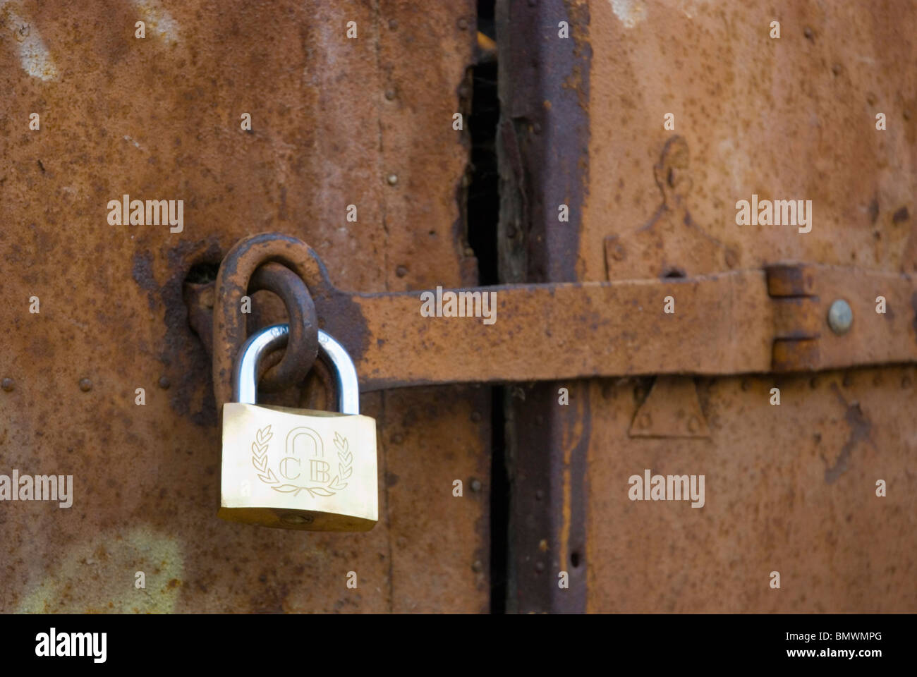 New lock in rusty door Stock Photo - Alamy