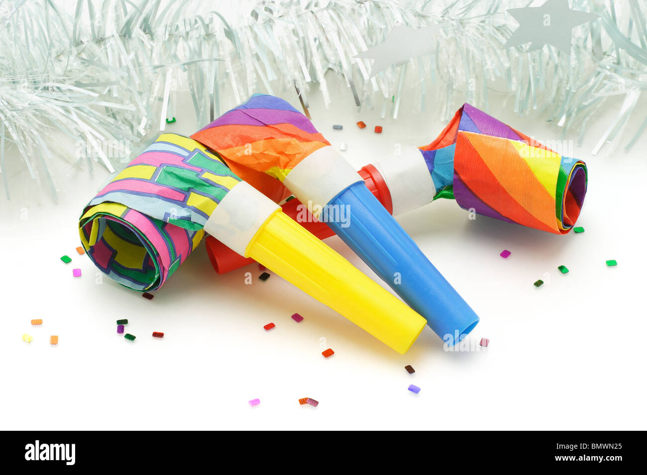 Three colorful paper party blowers or nosiemaker Stock Photo - Alamy