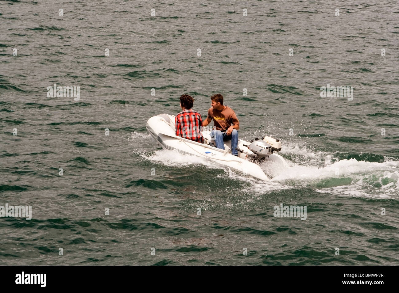 Two men in a speedboat Stock Photo - Alamy