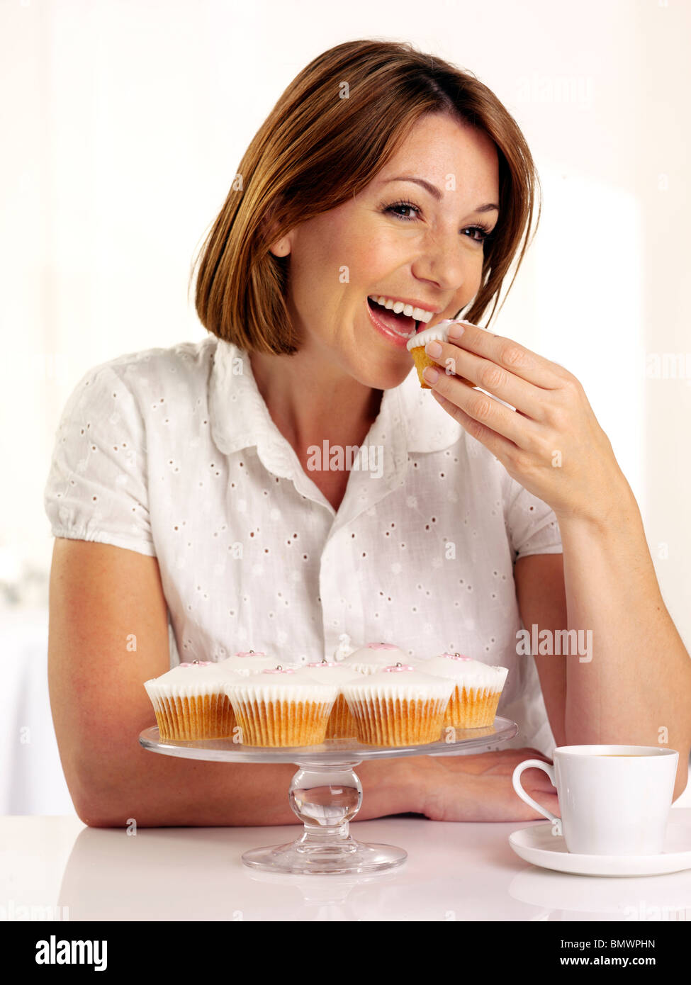 WOMAN EATING A CUPCAKE Stock Photo - Alamy
