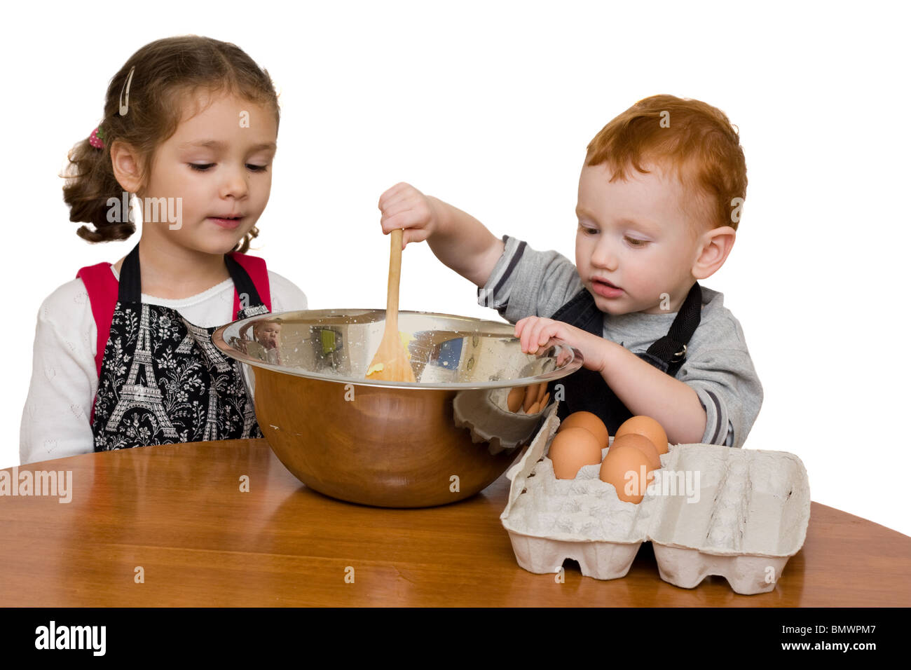 Two kids helping prepare cake in mixing bowl. Isolated on white Stock ...