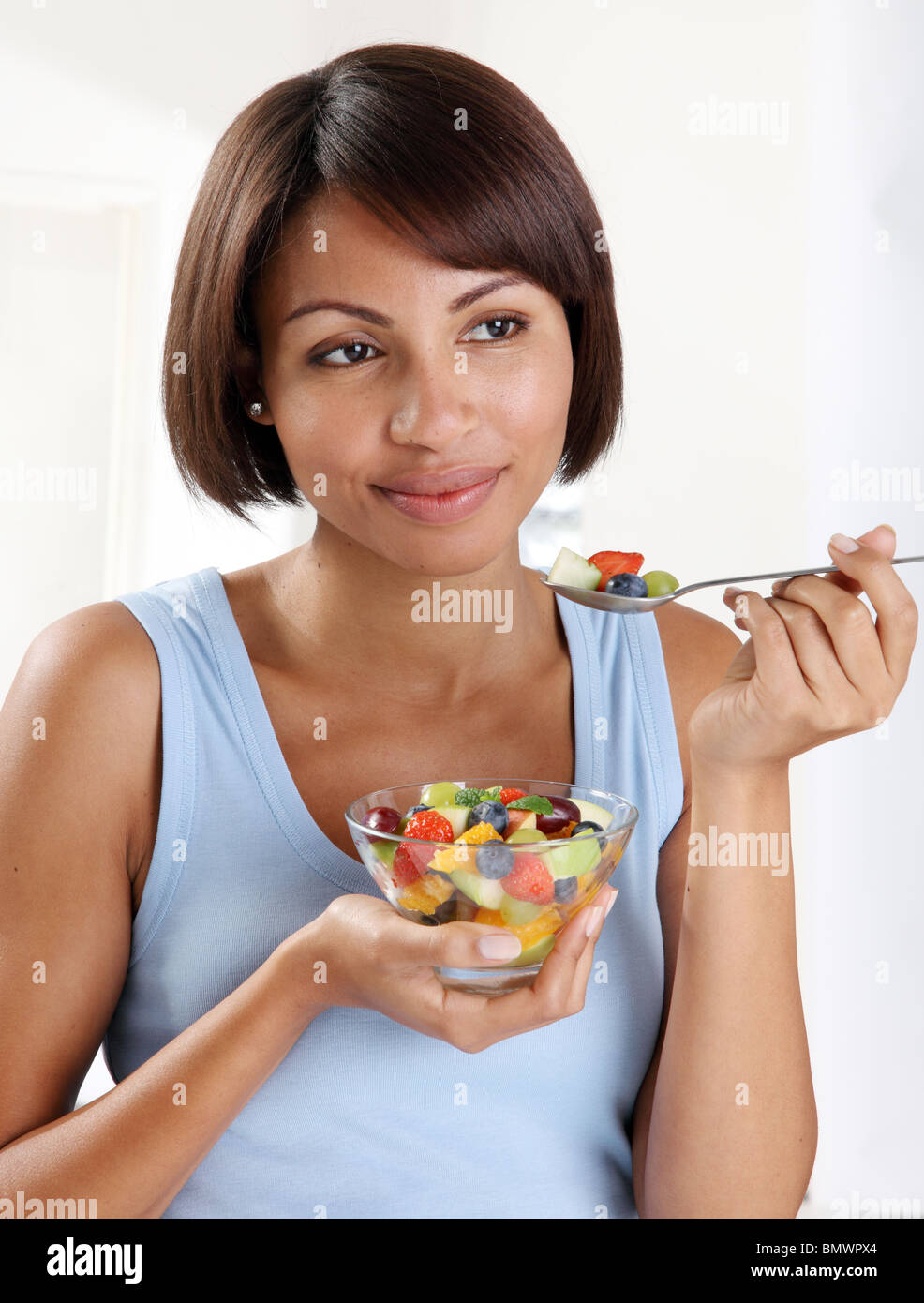 WOMAN EATING FRESH FRUIT SALAD Stock Photo - Alamy