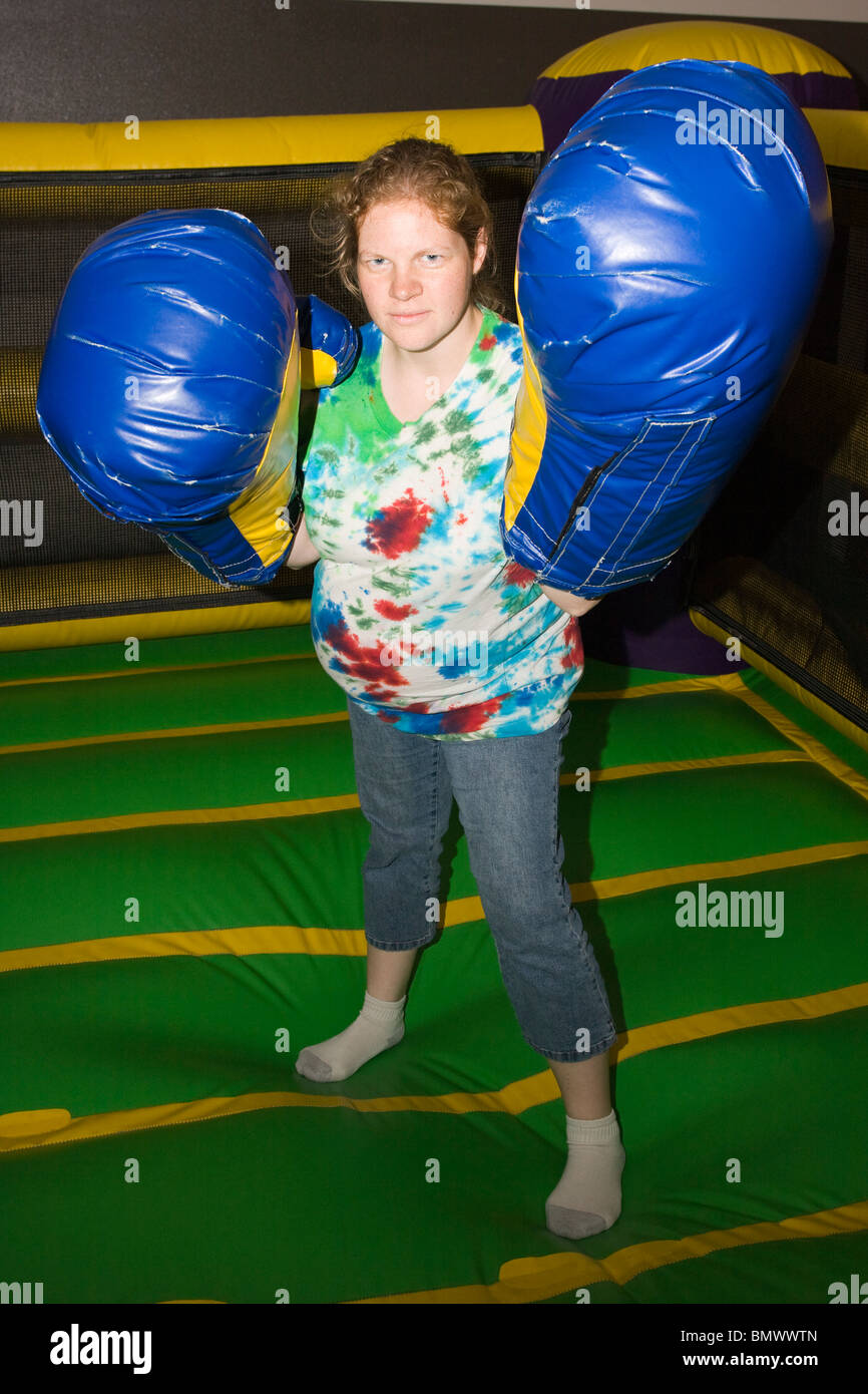 Pregnant woman, wearing tie dye shirt, with humorous oversize boxing ...