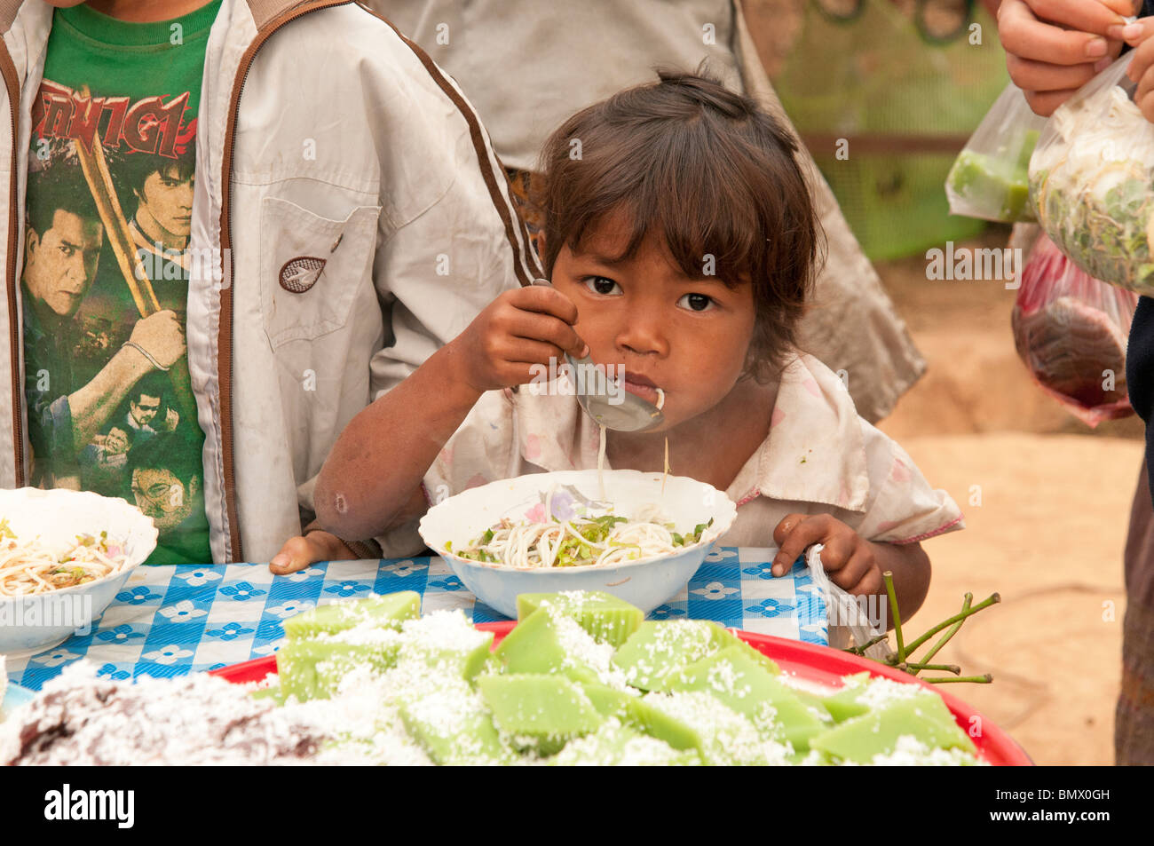 A young girl eating a bowl of noodles in Muang Ngoi Northern Laos Stock ...