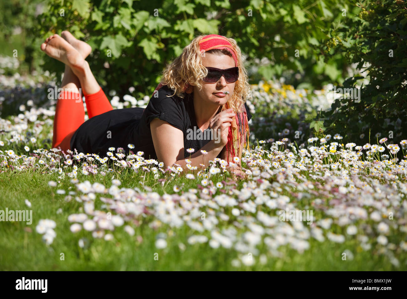 Girl in garden between flowers Stock Photo - Alamy