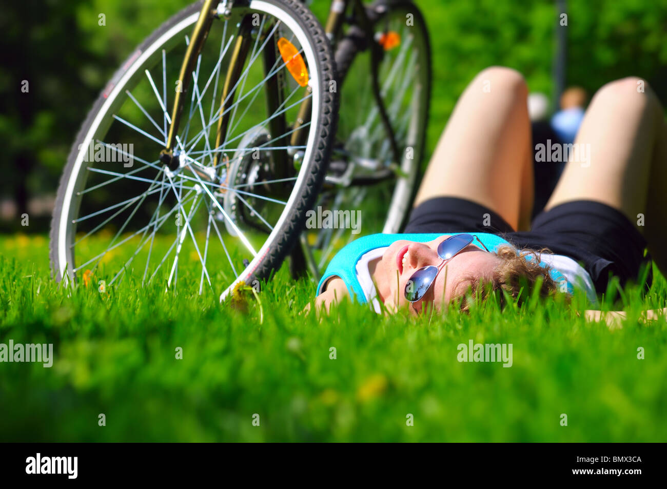 woman is lying near her bicycle Stock Photo - Alamy