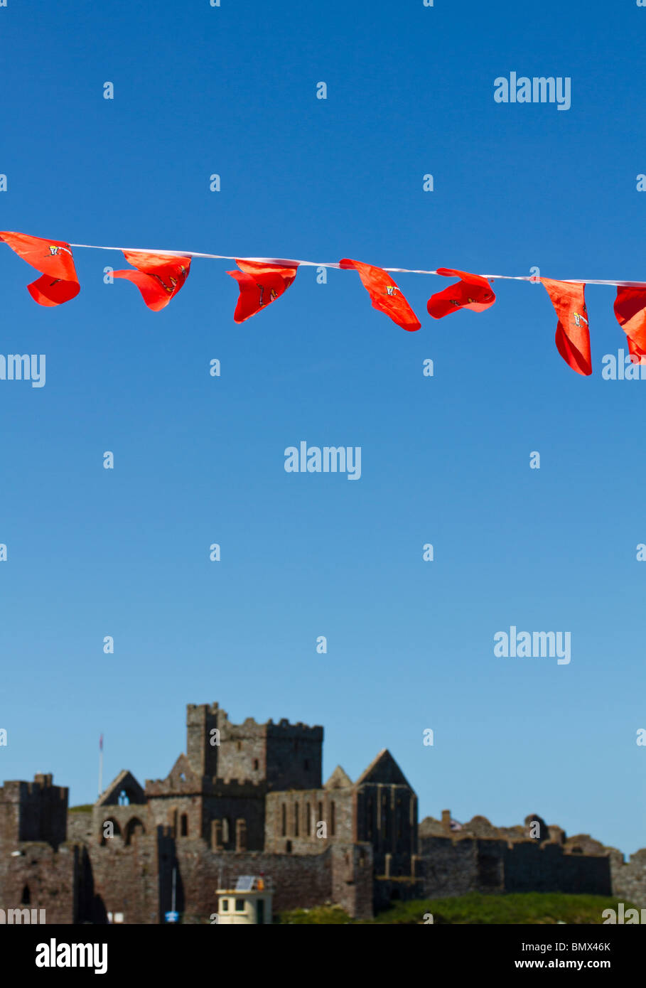 Peel Castle in Isle of Man with red flags on the foreground Stock Photo ...