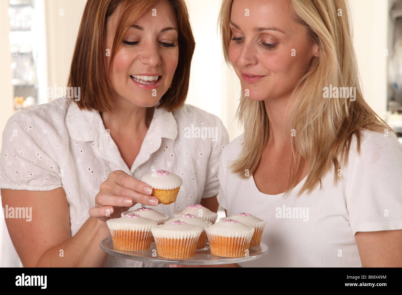 TWO WOMEN EATING CUPCAKES Stock Photo - Alamy