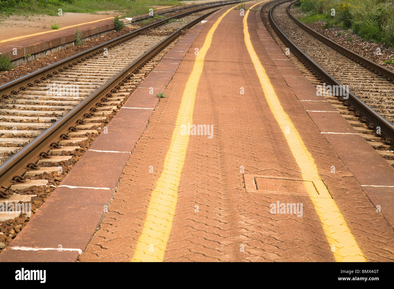 Railway and platform with yellow painted lines Stock Photo - Alamy