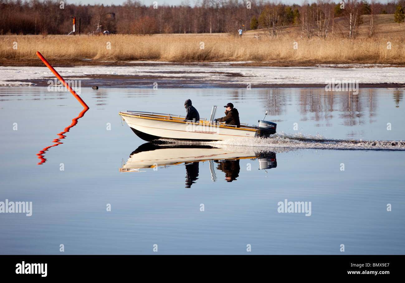 Two caucasian men on a motorboat / skiff at river Oulujoki Finland ...