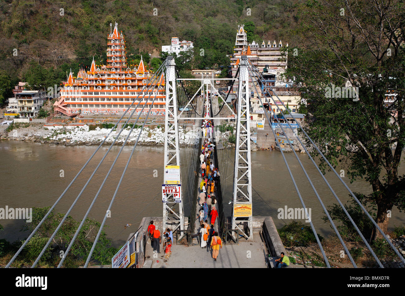 People crossing the Lakshmanjhula Bridge over the River Ganges ...