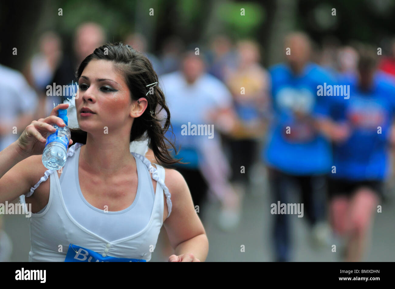 Mass participation running event competitor drinking water, London ...
