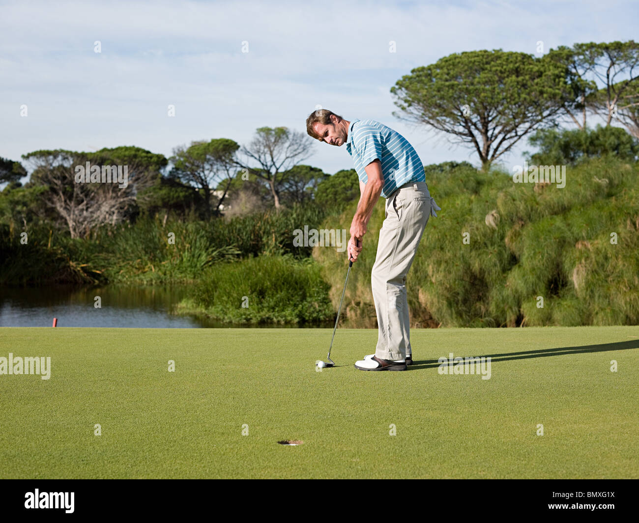 Man playing golf, on putting green Stock Photo - Alamy