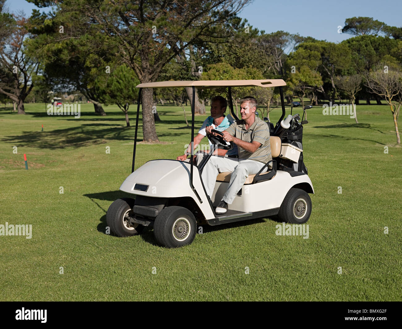 Two men driving golf cart hi-res stock photography and images - Alamy