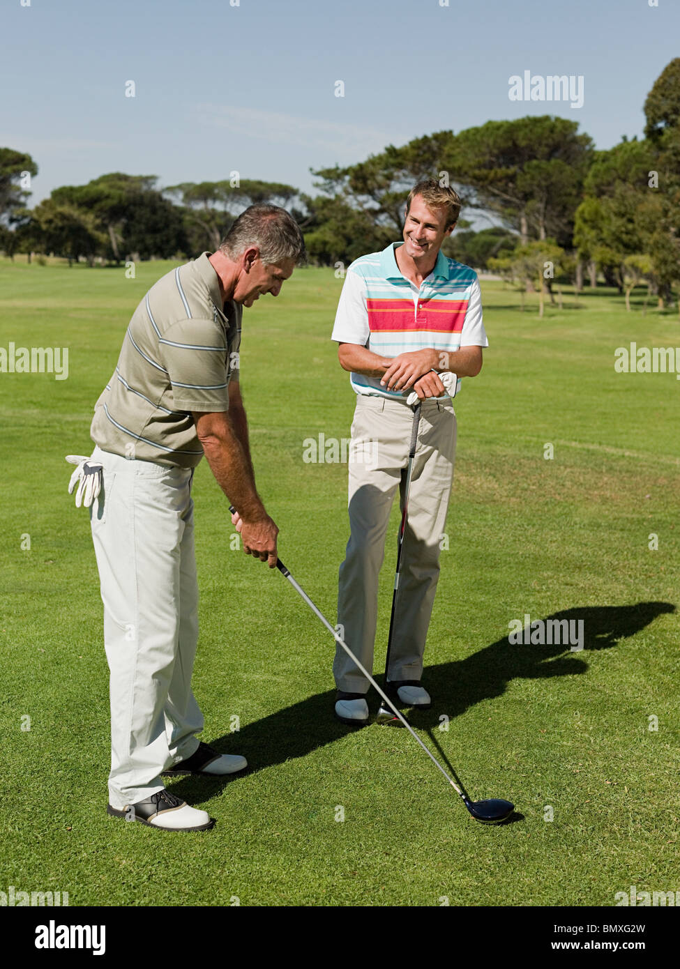 Two mature men playing golf together Stock Photo - Alamy