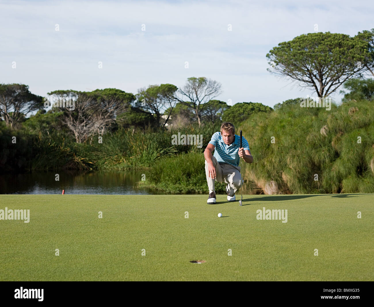 Man playing golf, on putting green Stock Photo - Alamy