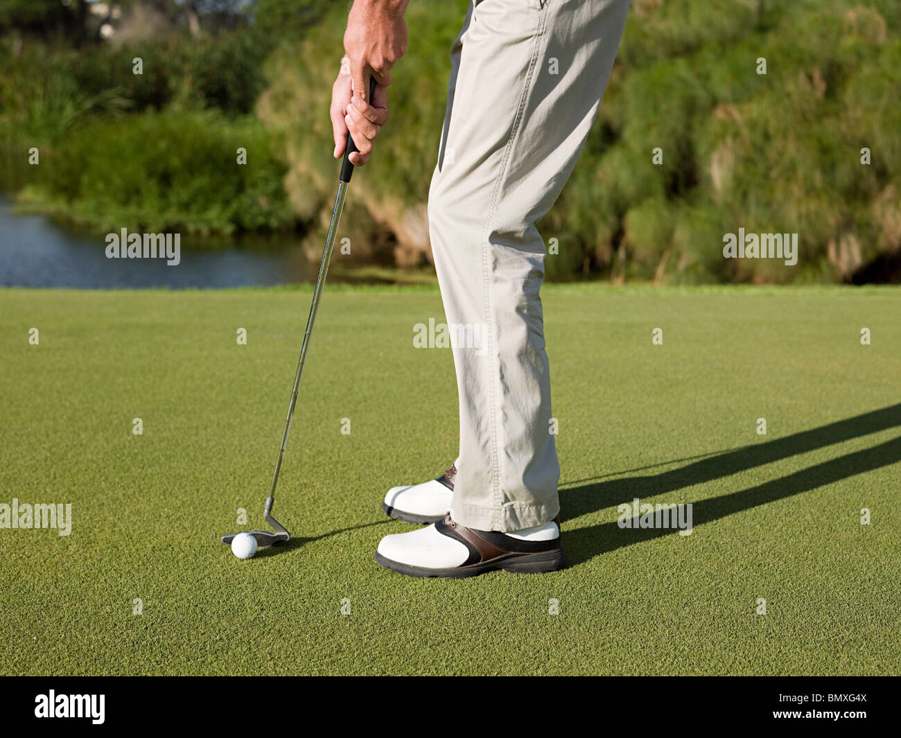 Man playing golf on golf course Stock Photo - Alamy