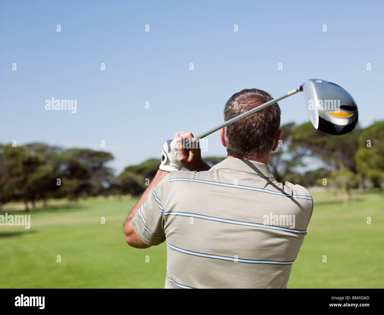 Man playing golf on golf course Stock Photo - Alamy