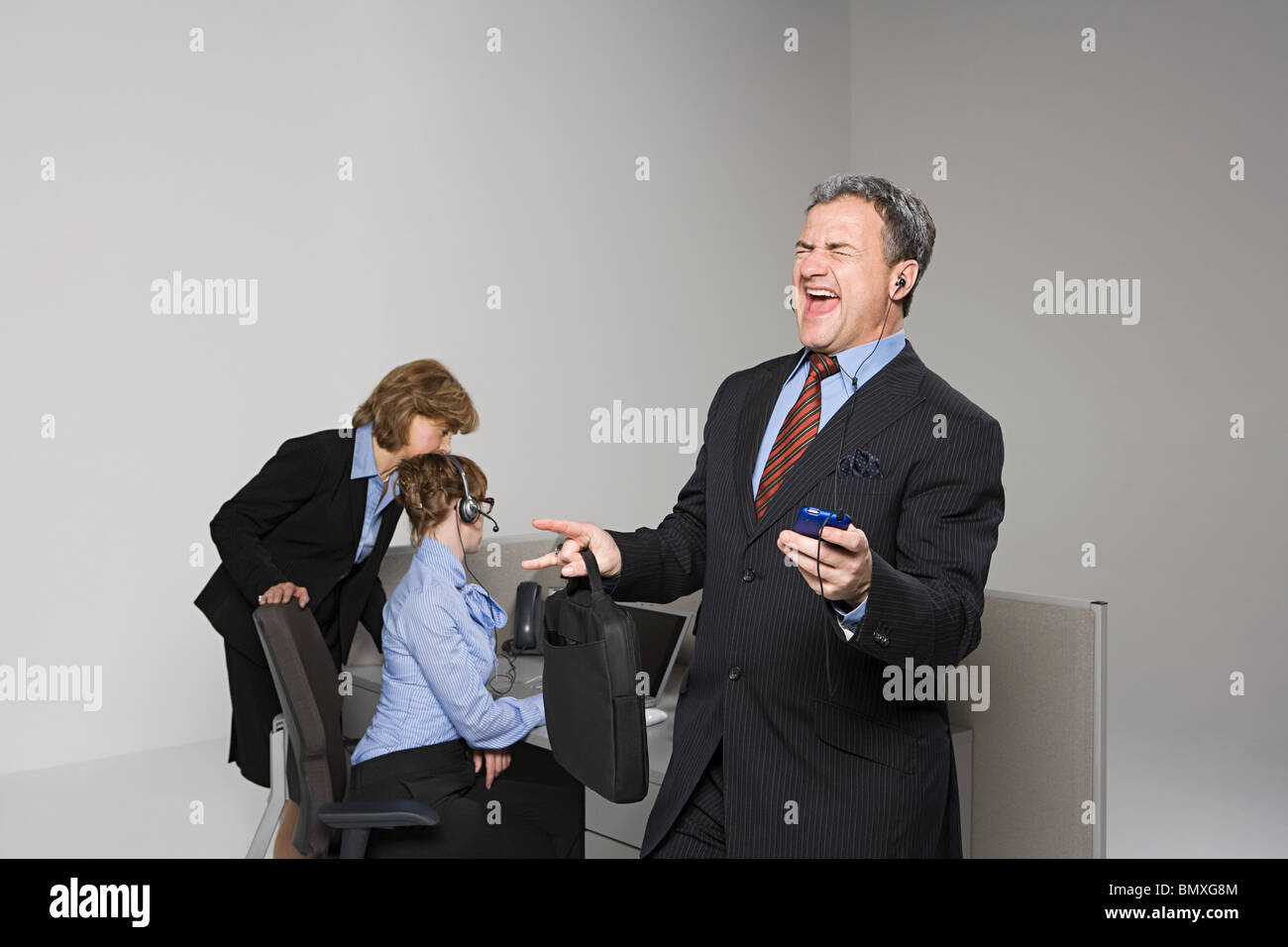Businessman listening to MP3 player Stock Photo - Alamy