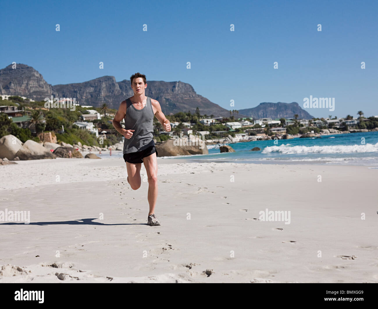 Young man jogging on beach Stock Photo - Alamy