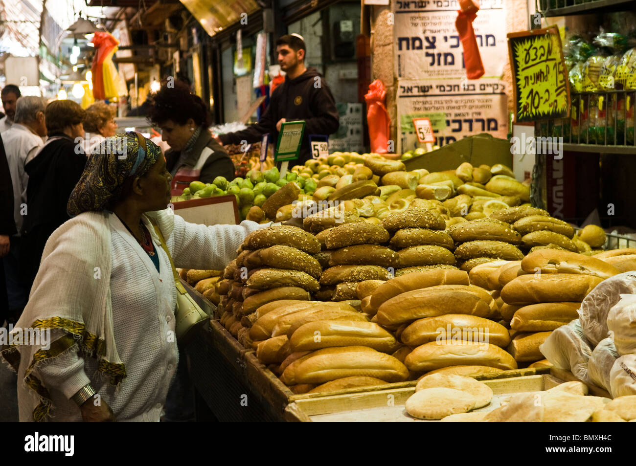An Ethiopian woman buying fresh break at the colorful Mahane Yehuda ...