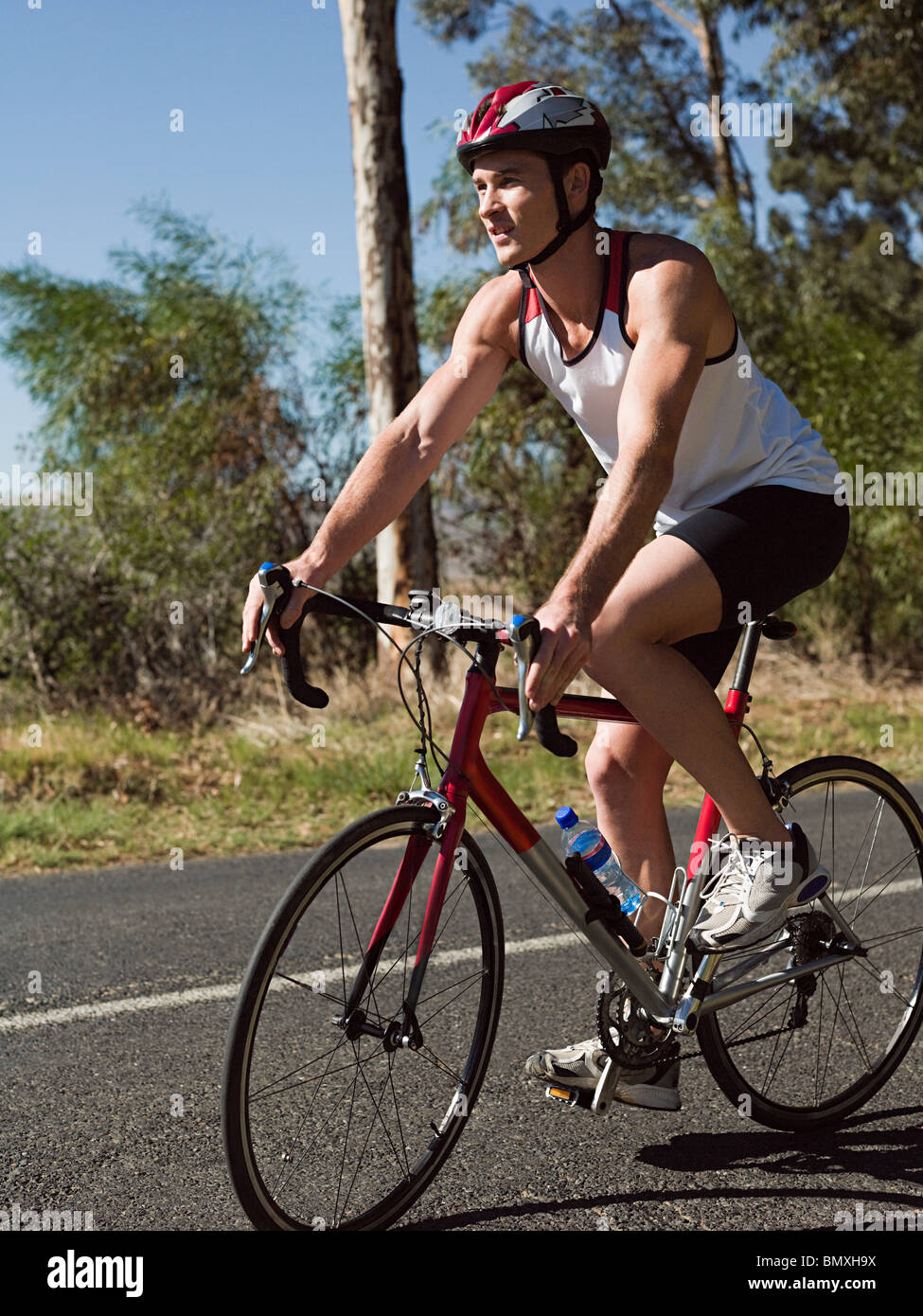 Young man cycling on road Stock Photo - Alamy